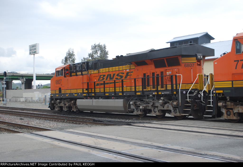 BNSF 6807 passes me by as she heads west toward the UP Colton Yard with the I-10 Bridge in the ...